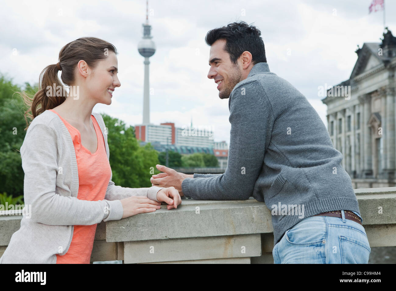 Germany, Berlin, Couple standing on bridge and talking Stock Photo - Alamy
