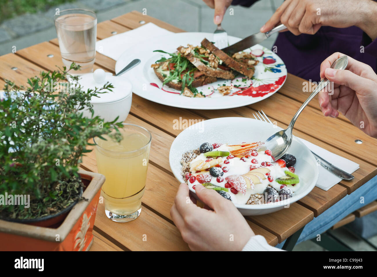 Germany, Berlin, Couple eating food at cafe Stock Photo - Alamy