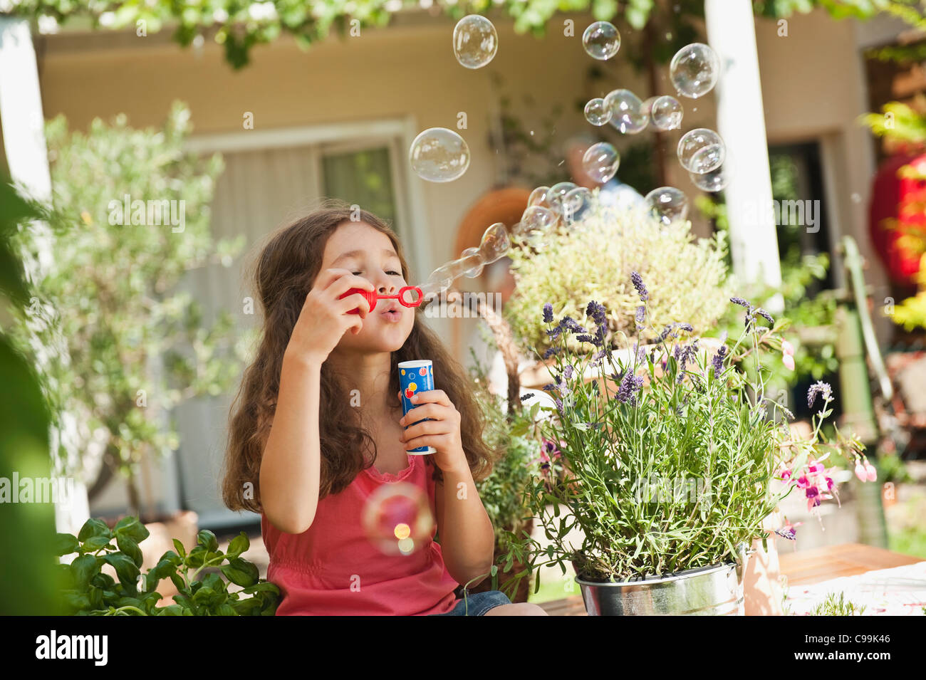 Germany, Bavaria, Girl blowing soap bubbles in garden Stock Photo - Alamy