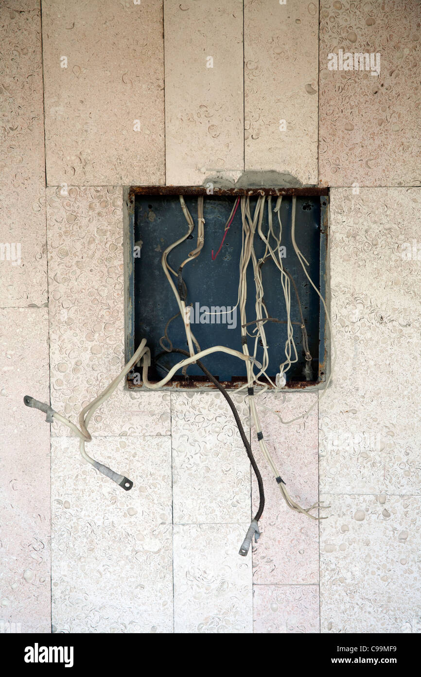 Wires hanging from a wall where the switch panel has been looted ...