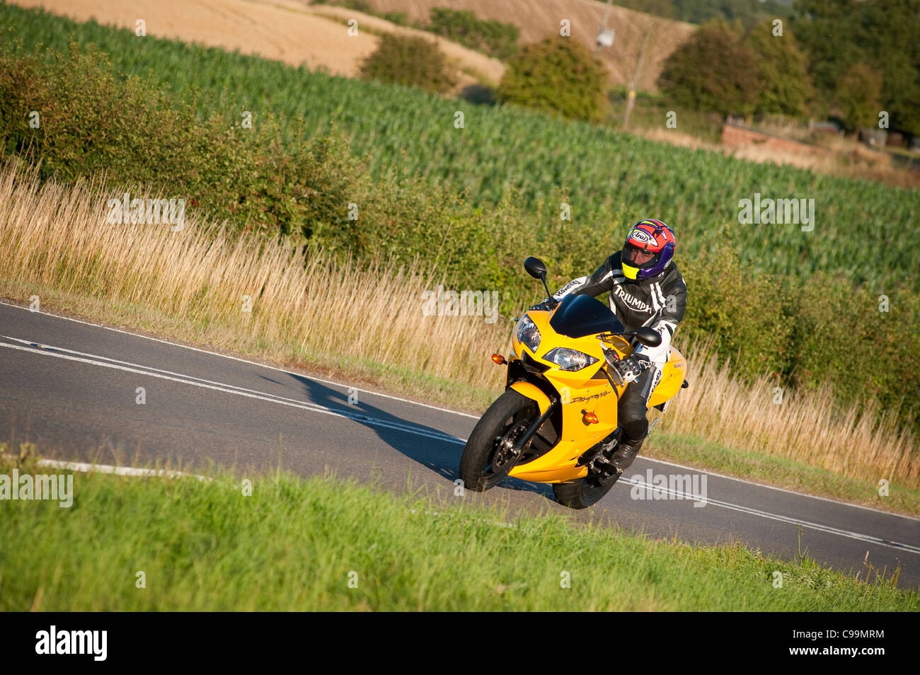 Motorcyclist riding along a rural road in England Stock Photo - Alamy