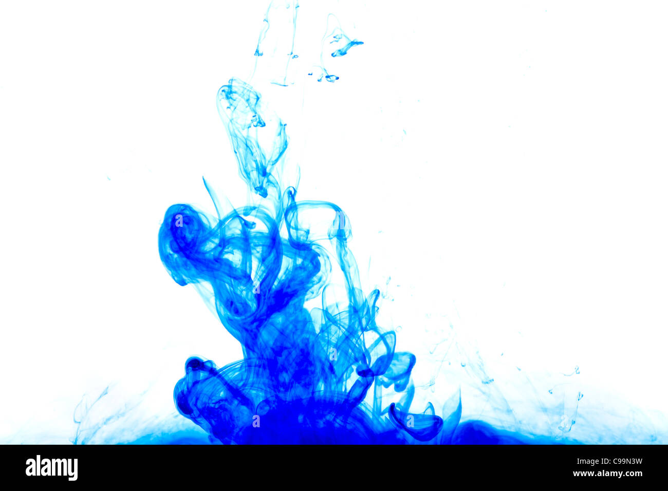 Side view of blue ink diffusing into a tank of water Stock Photo - Alamy