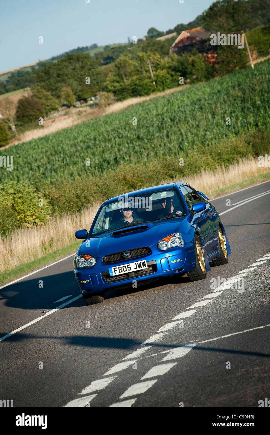 Blue Subaru Impreza sports car being driven through rural England in ...