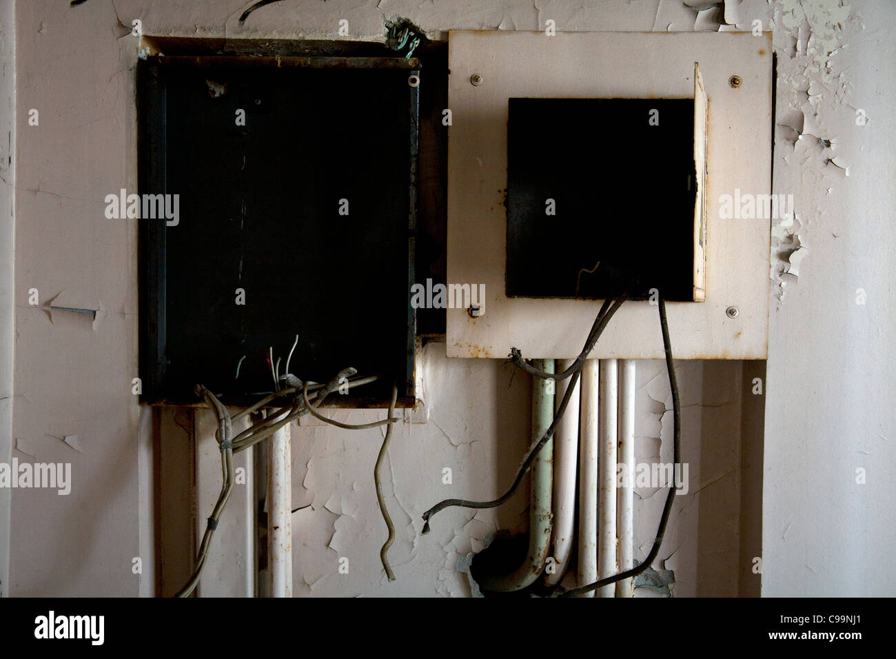 Wires hanging from a wall where the switch panel has been looted ...