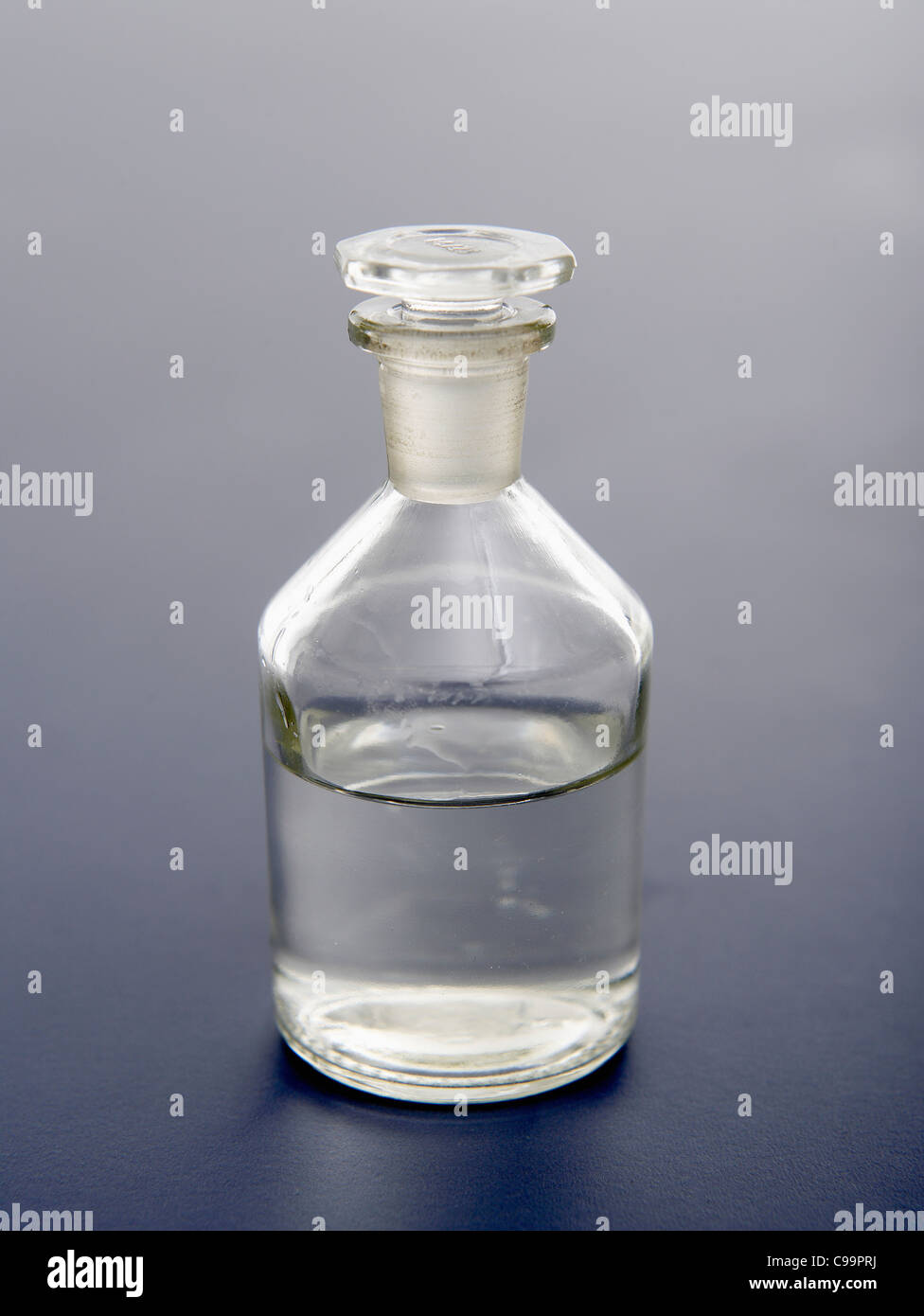 Glass bottle with liquid on gray background Stock Photo - Alamy