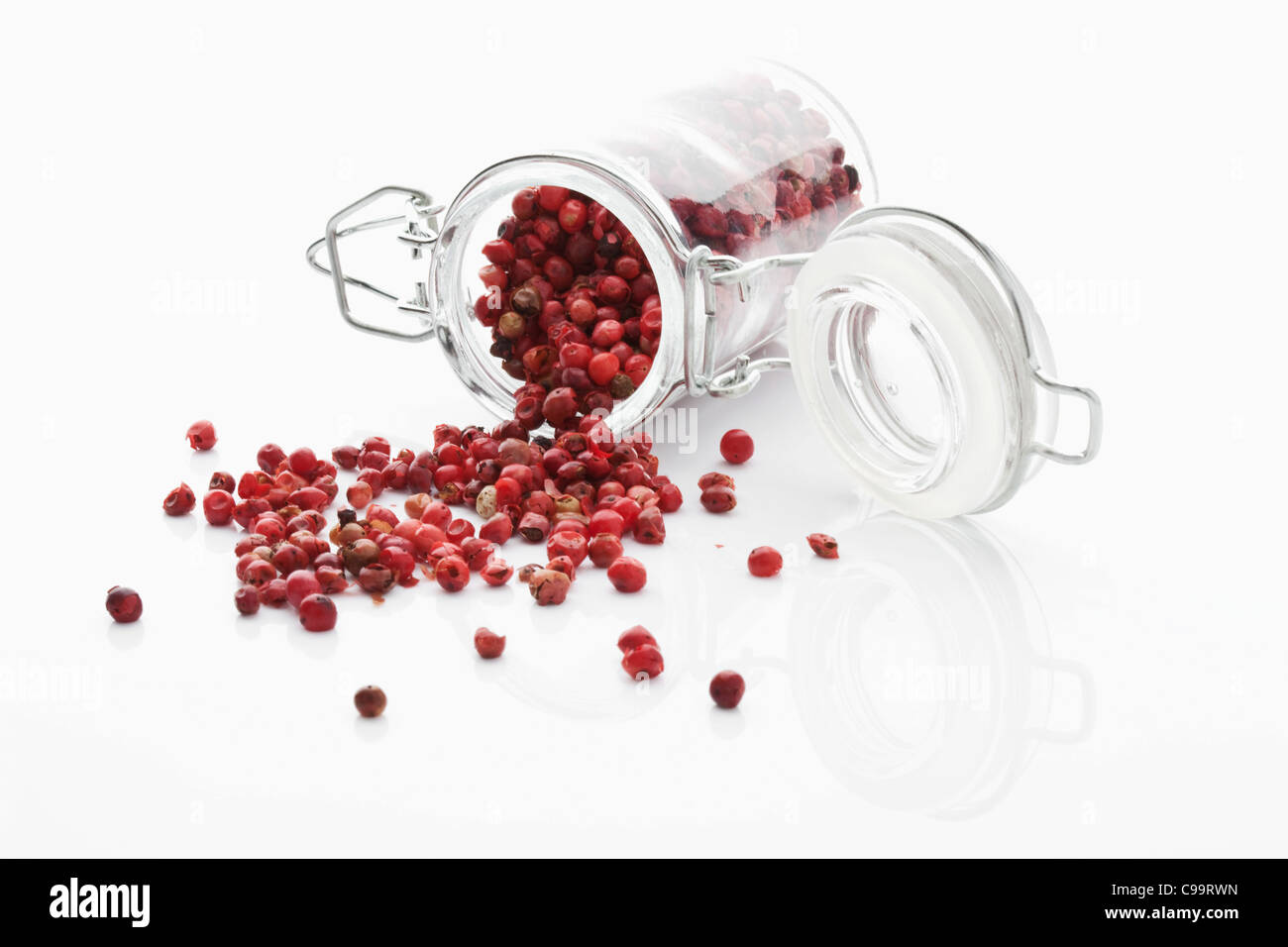 Dry red pepper in glass jar spilling on white background Stock Photo ...