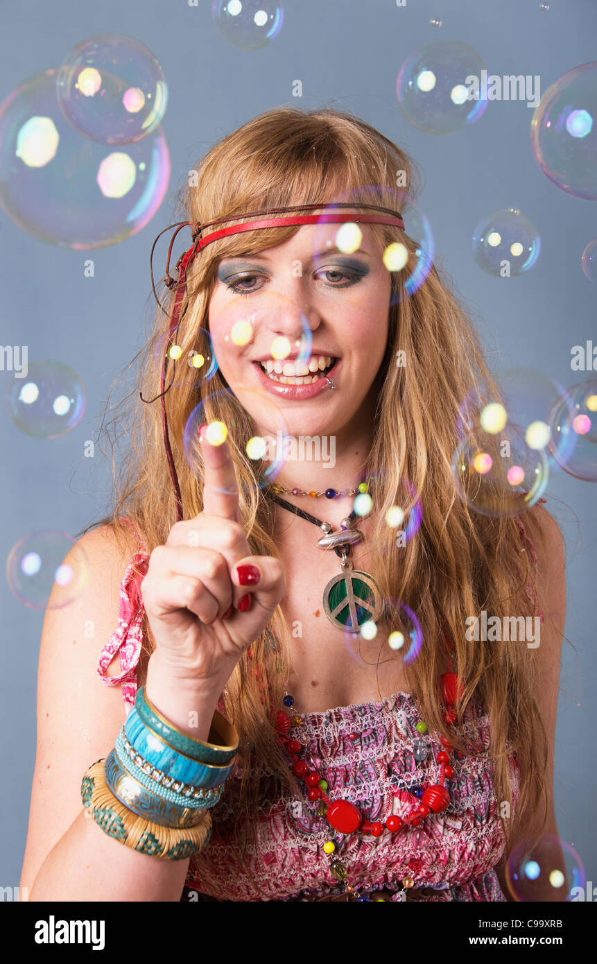 Young hippie woman with bubbles against grey background, smiling Stock ...