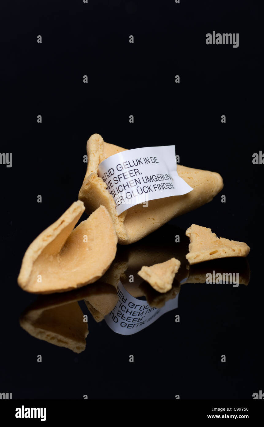 Close up of broken fortune cookie on black background Stock Photo - Alamy