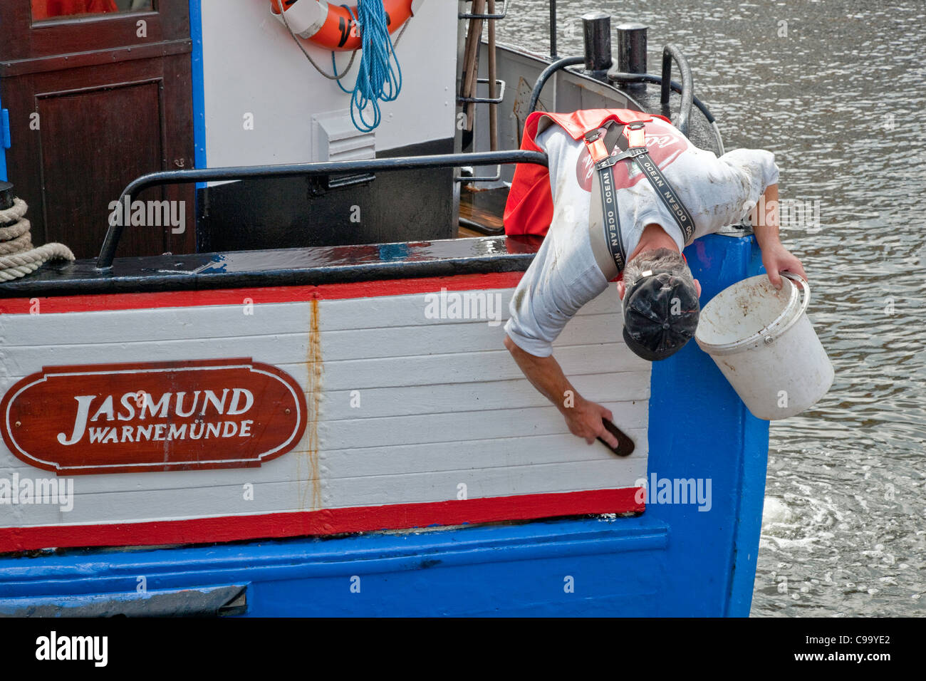 Fisher Man is cleaning his boat in Warnemuende or Warnemunde; Sea Side ...