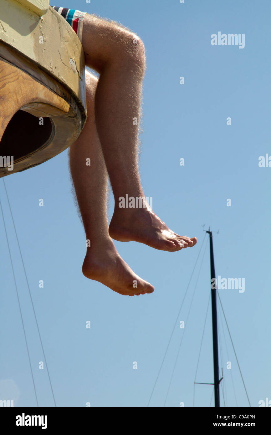 Person legs hanging dangling on touristic charter boat Stock Photo - Alamy