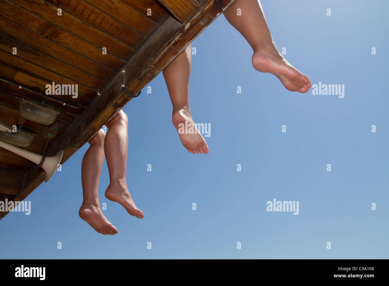 People legs hanging dangling on touristic boat Stock Photo - Alamy