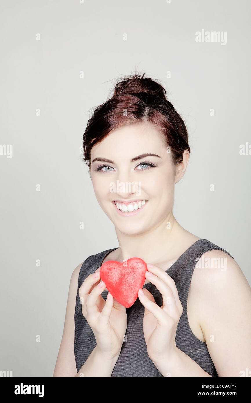woman with a love heart shaped symbol tp give to you Stock Photo - Alamy