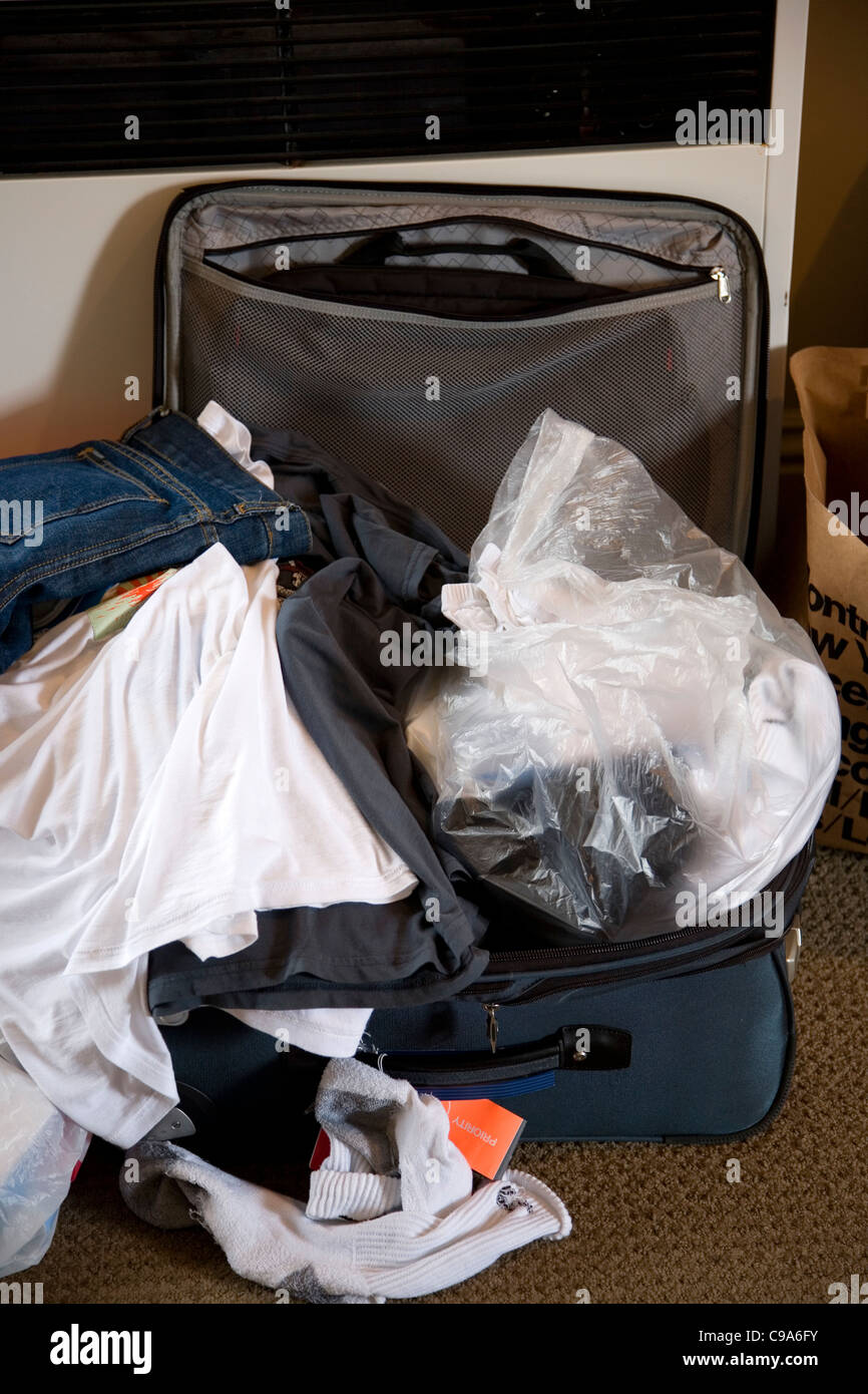 Untidy heap of clothes in travel suitcase Stock Photo - Alamy