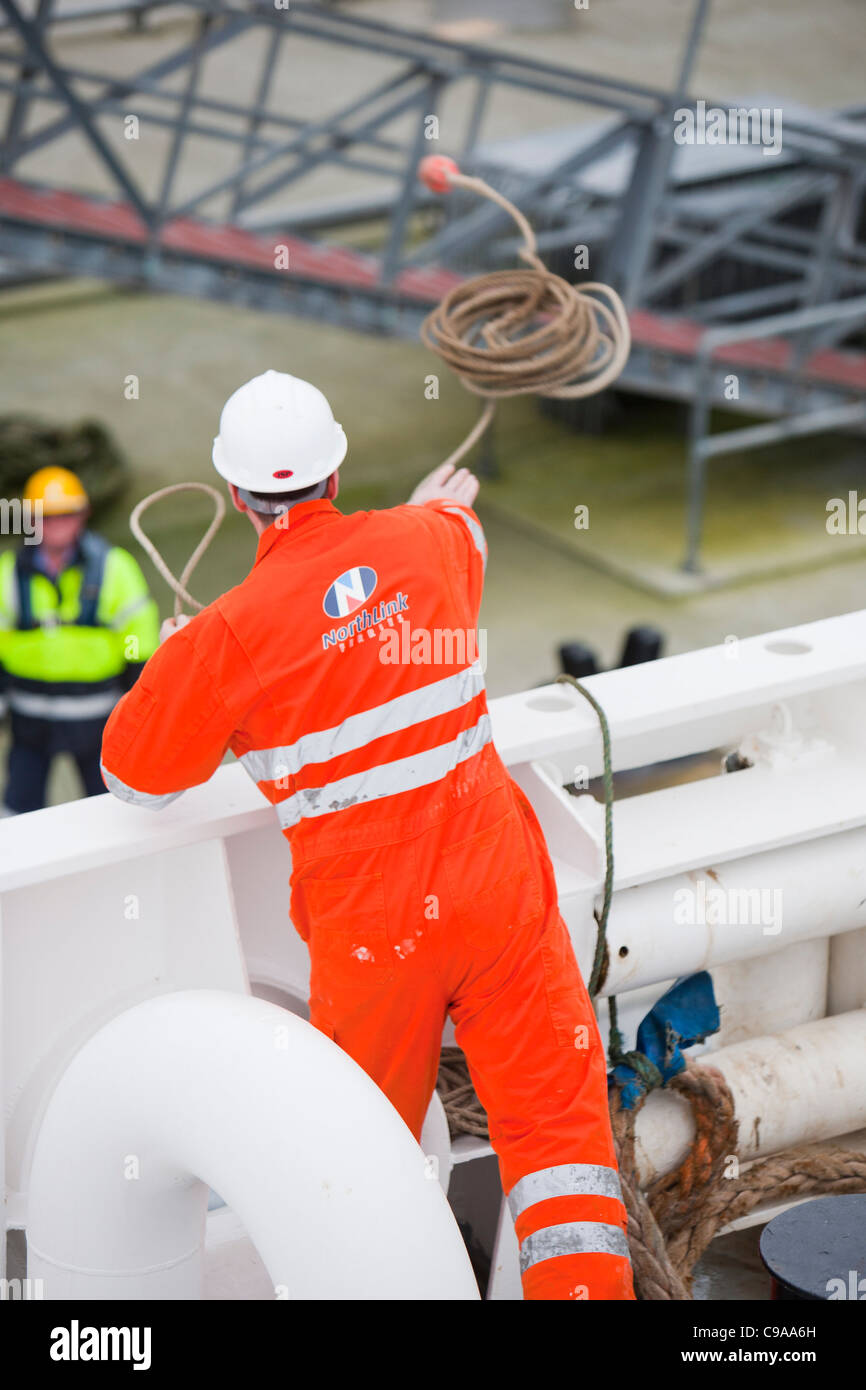 A deck hand throws a mooring rope to shore on a Northlink ferry in ...