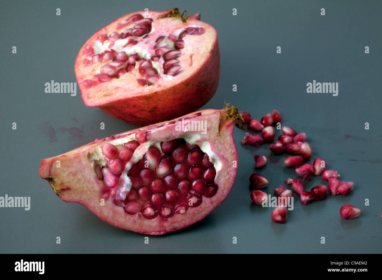 A pomegranate split open to display its red juicy seeds Stock Photo - Alamy