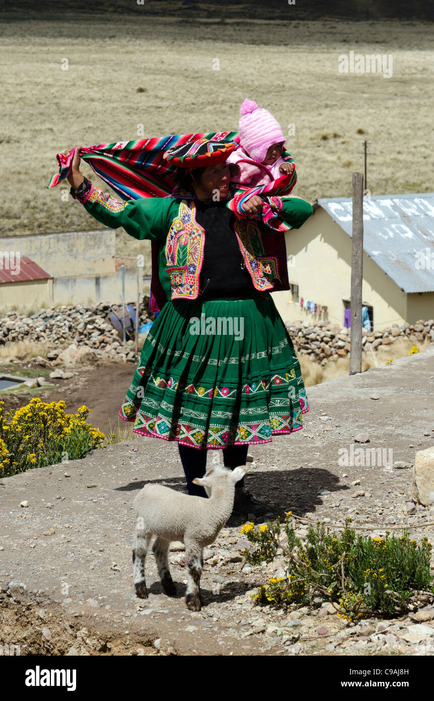 Woman wearing traditional peruvian costume carrying a baby Puno Peru ...