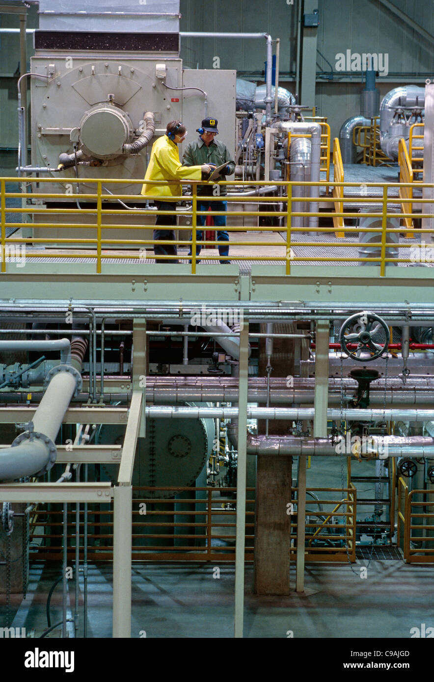 Worker at a gas turbine co-generation plant (natural gas to electric ...