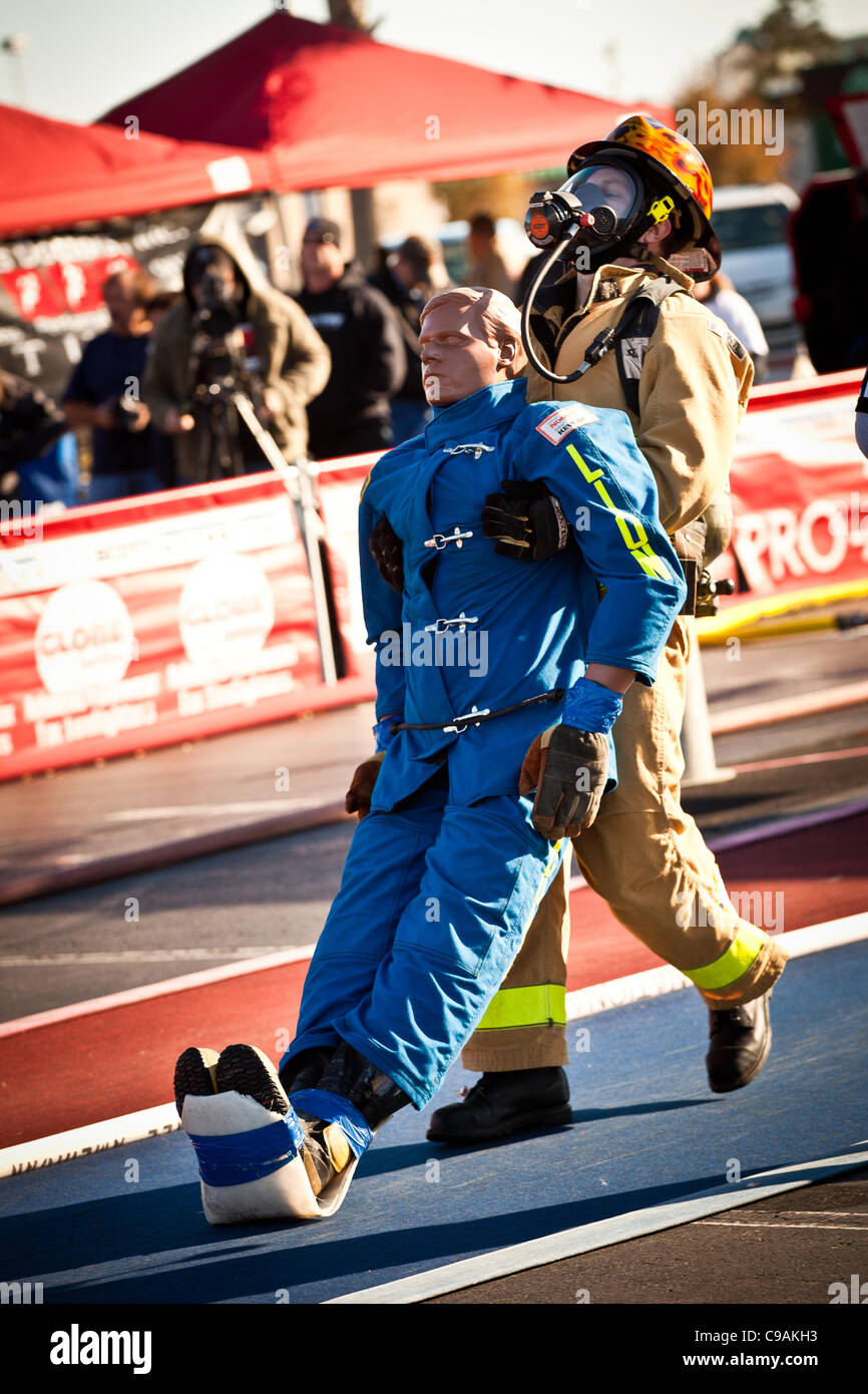A firefighter drags a 175-pound mannequin backwards wearing full ...