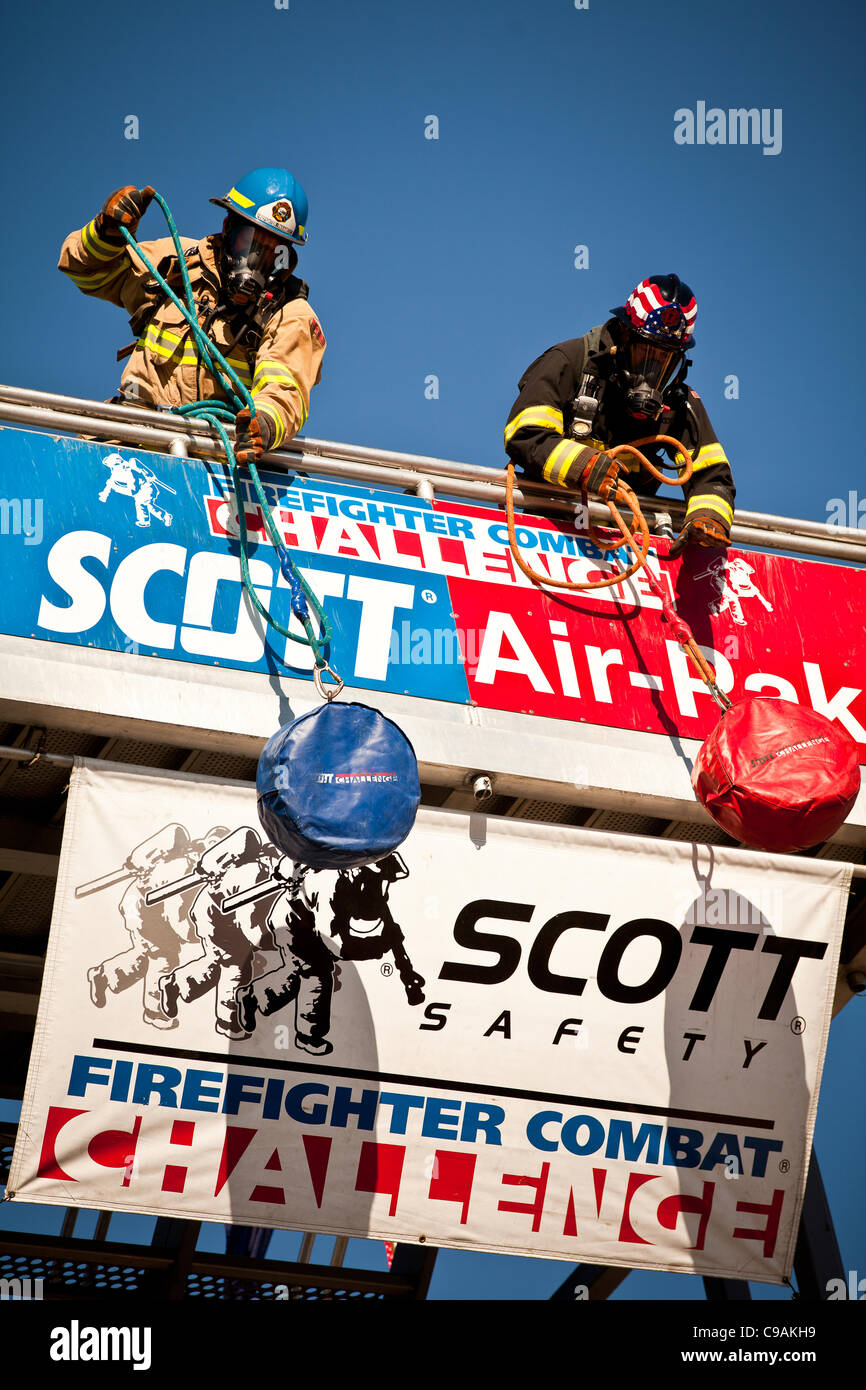 Two firefighters hoist a 42-pound firehose up six stories wearing full ...