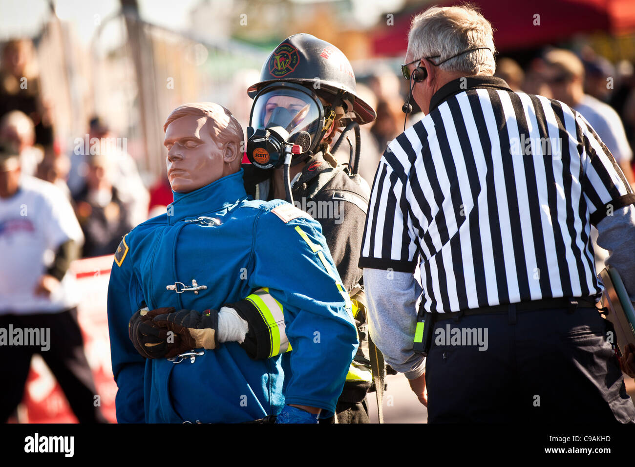 A woman firefighter is watched by the referee as she drags a 175-pound ...