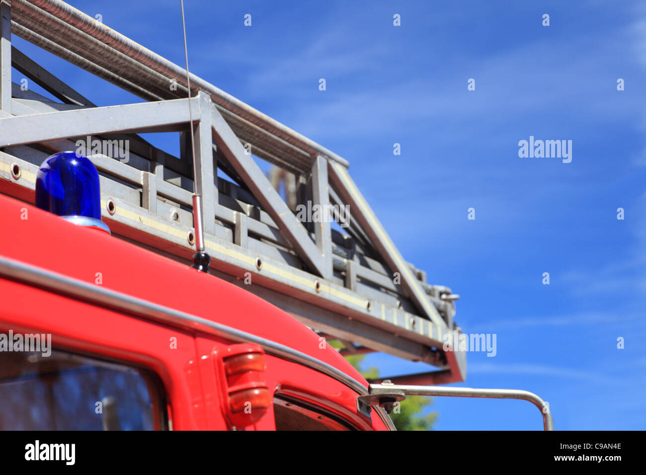 Ladder of a fire truck on the blue sky, emergency light on firetruck ...