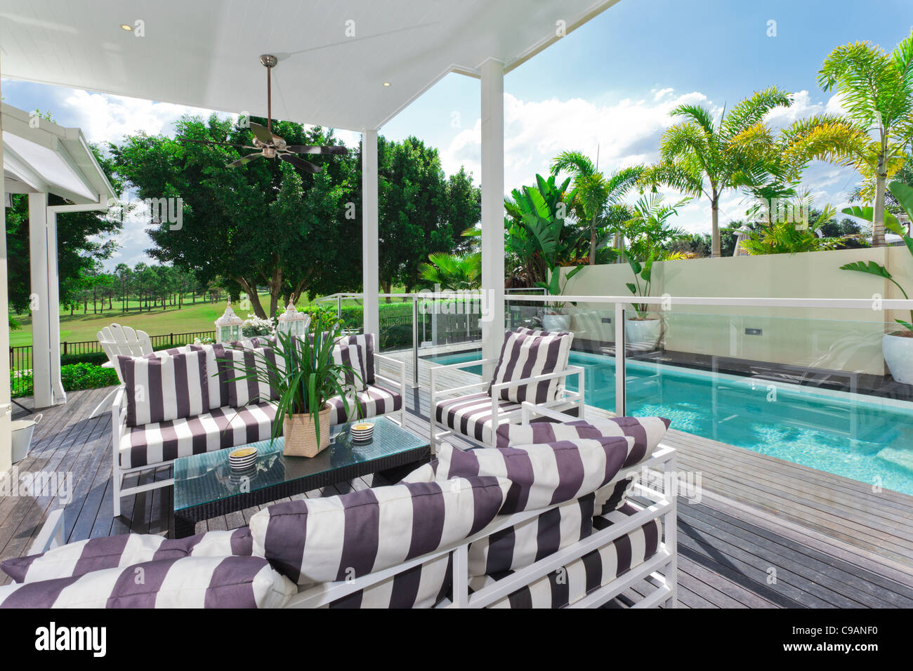 Stylish wooden outdoor deck overlooking a swimming pool and golf course ...