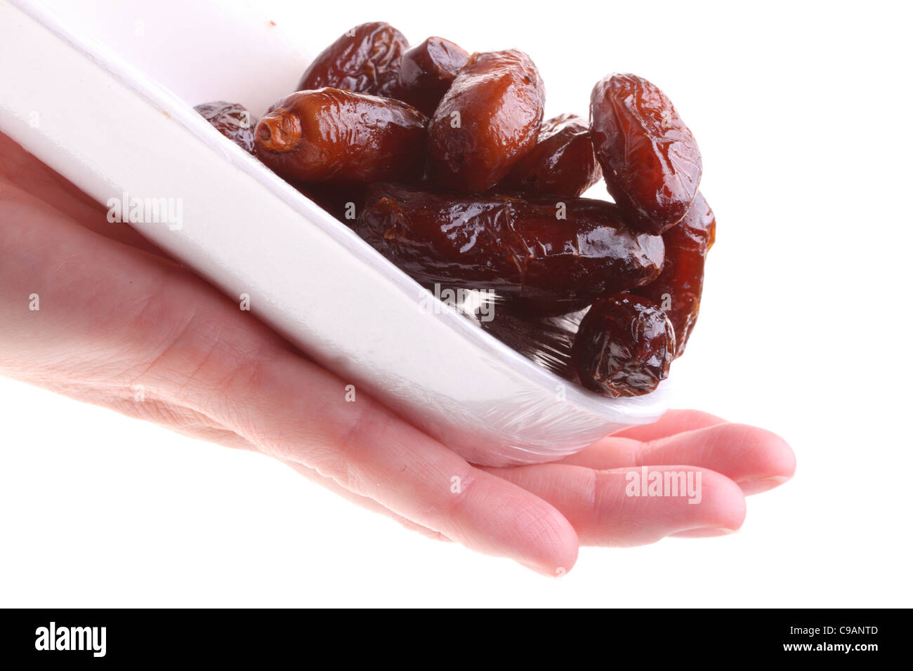 Dried date fruits in hand isolated on white background Stock Photo - Alamy