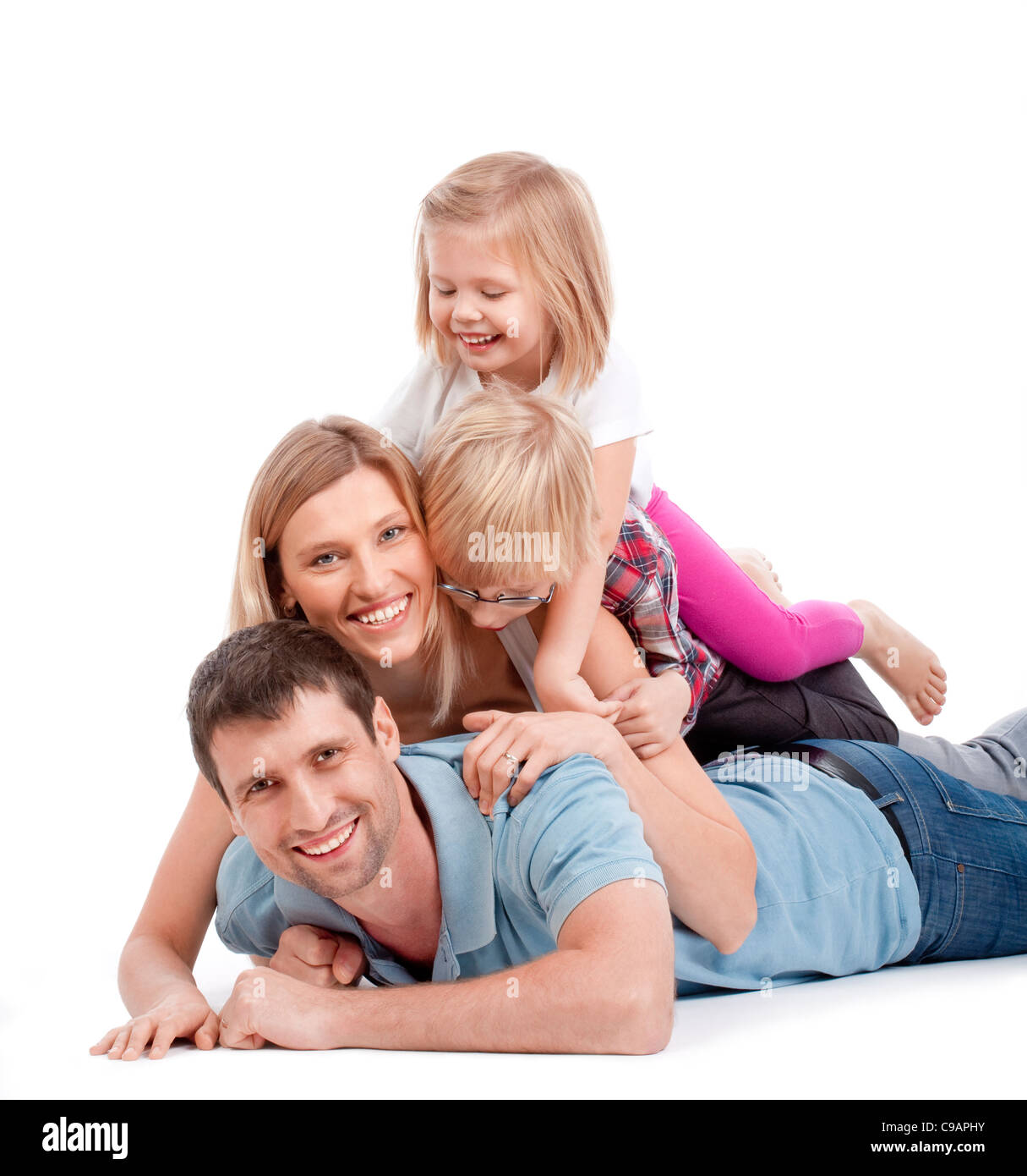 happy family having fun lying on top of each other in stack - isolated ...