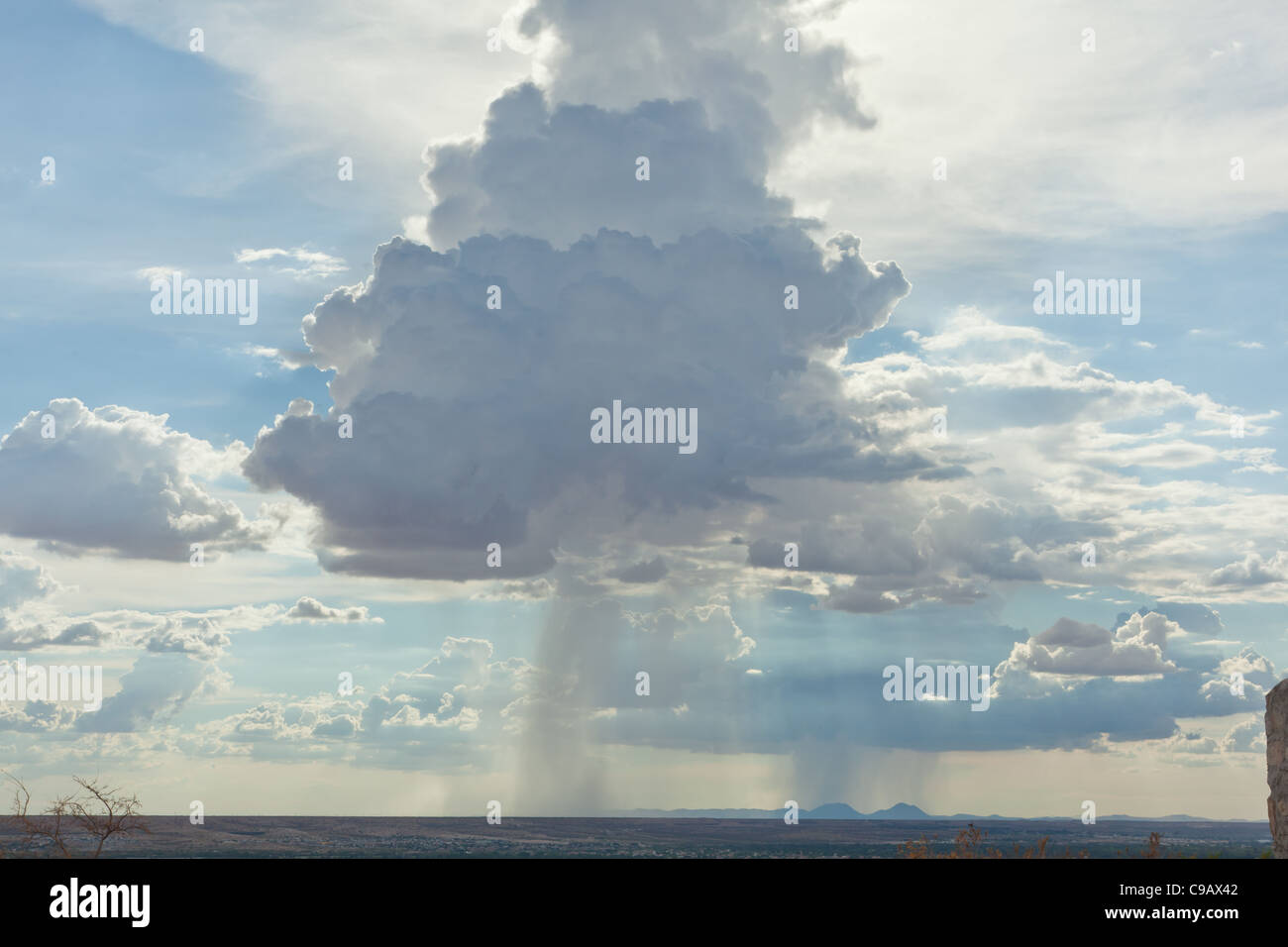 Large storm cloud with column of rain and sun above Stock Photo - Alamy