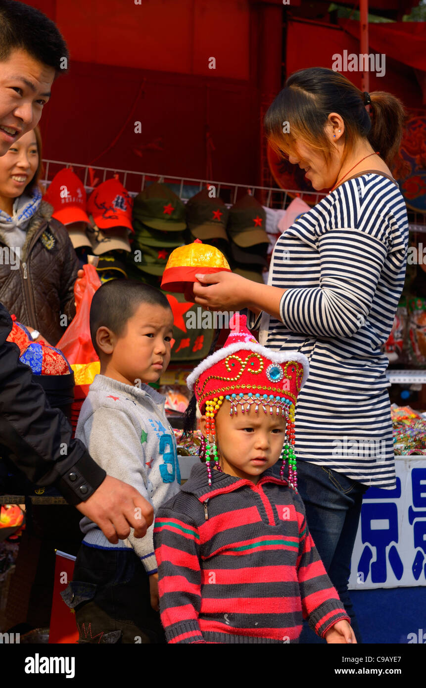 Chinese family on vacation on National week shopping for hats for their ...