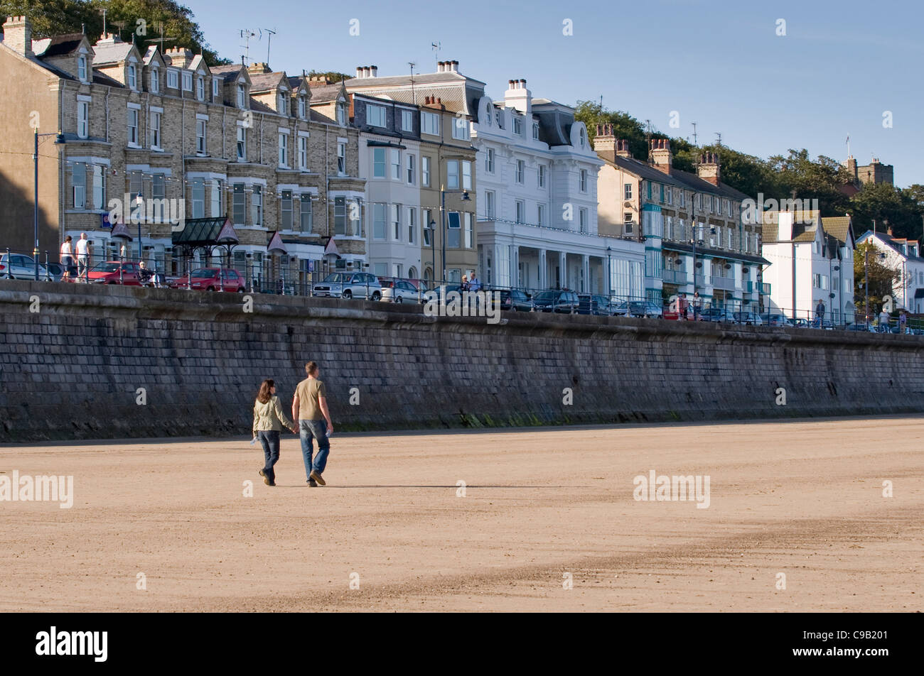 Couple (man woman) relaxing & walking hand in hand on quiet flat sandy ...