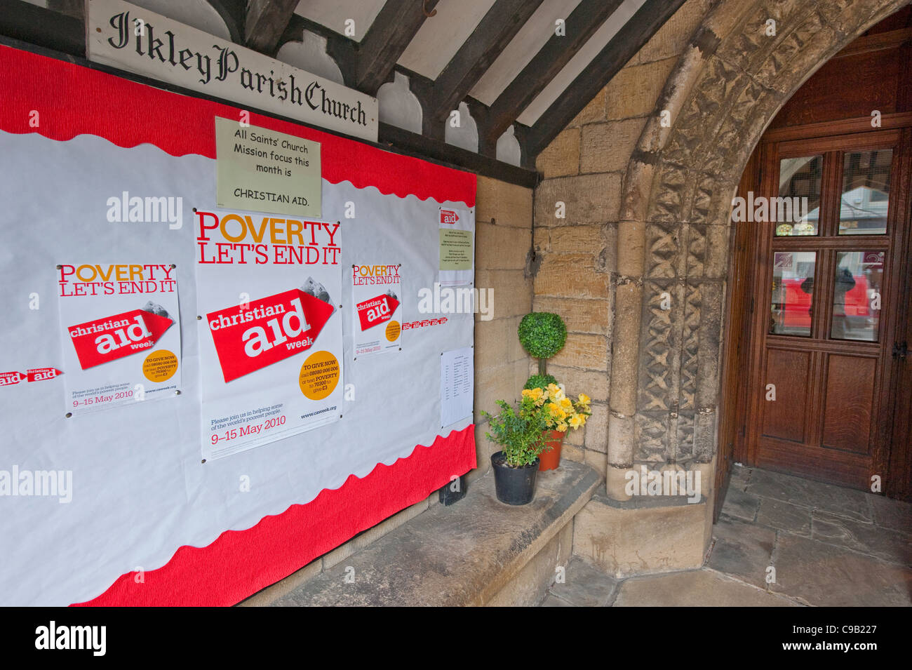 Inside church porch (Christian Aid posters on display board, wooden ...