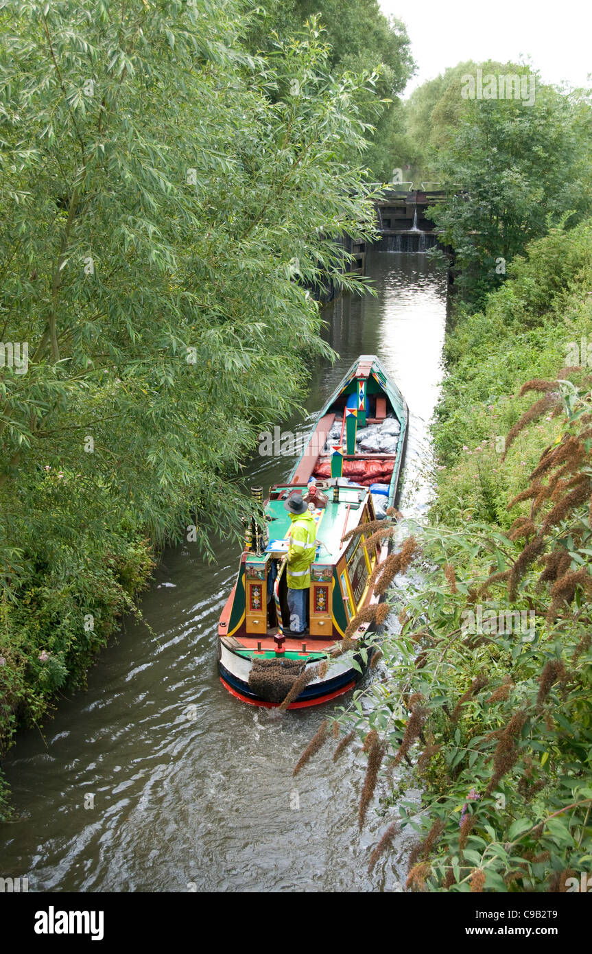 A working narrowboat carrying coal approaches Towney Lock on the Kennet ...