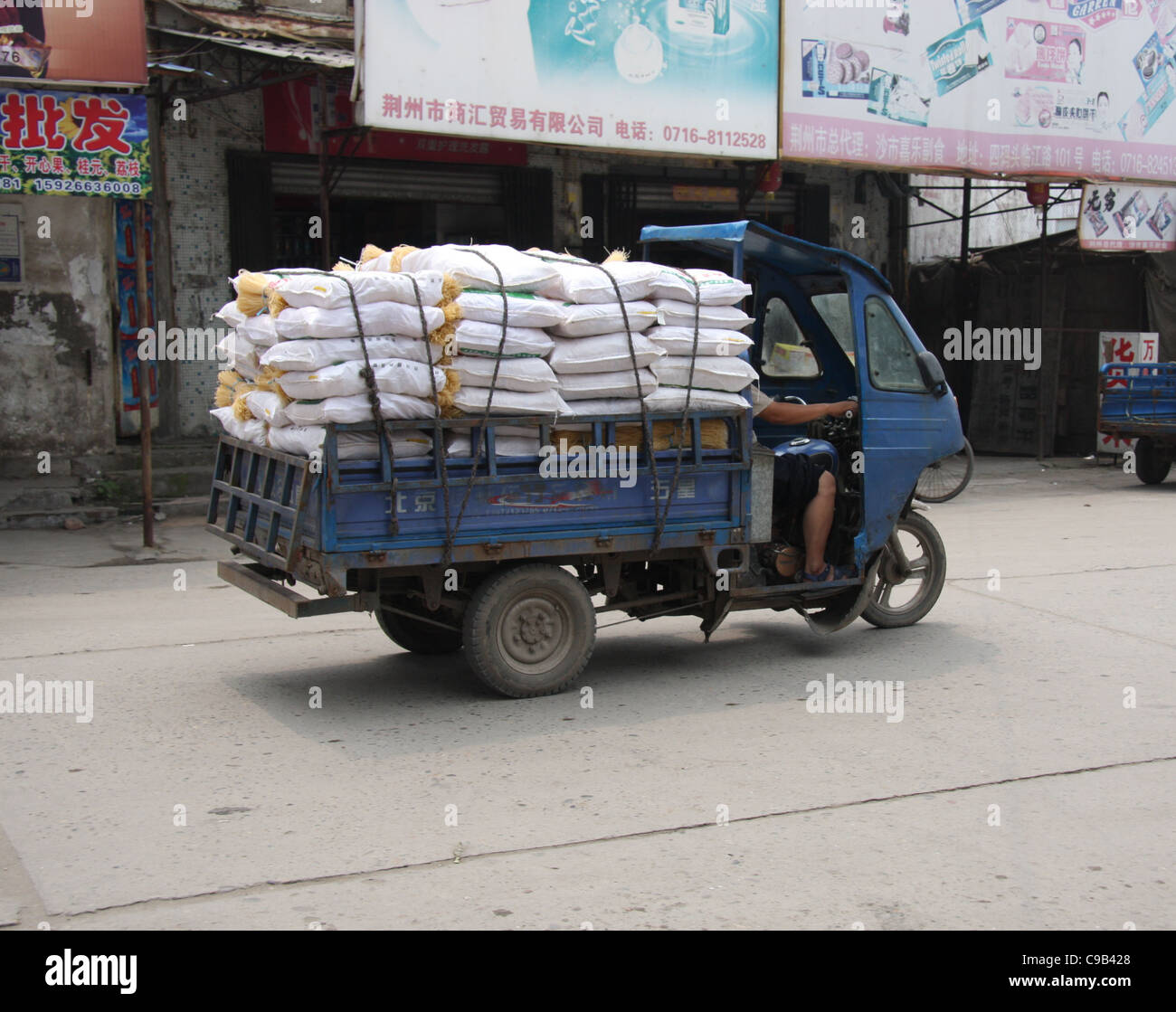 Small three wheel motorcycle with cab, loaded with bags, in Jingzhou ...