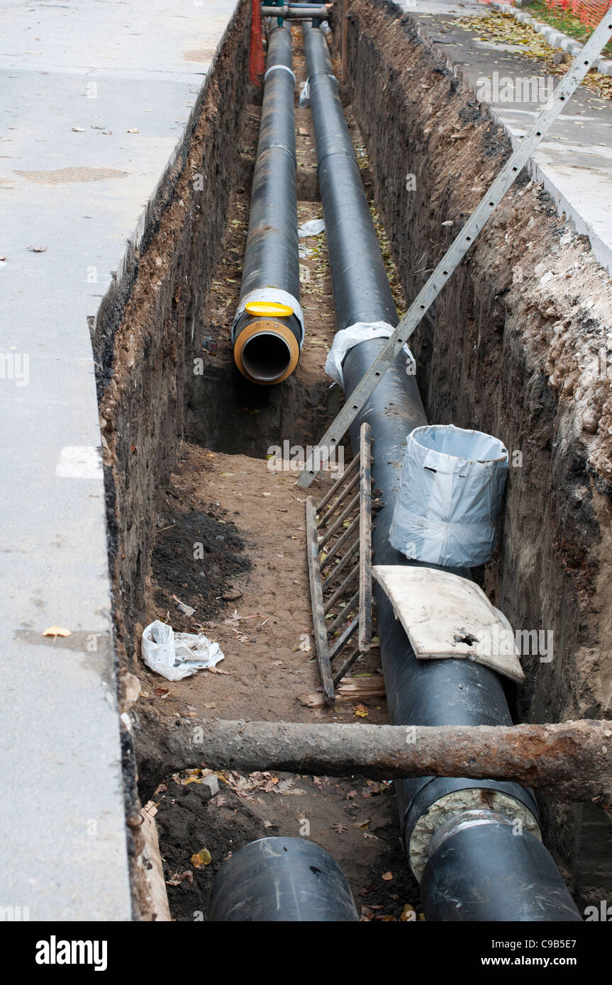 Installing pipes for hot water and steam heating. City heat pipeline ...