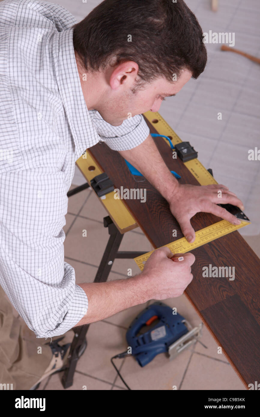 Man measuring wood flooring Stock Photo - Alamy
