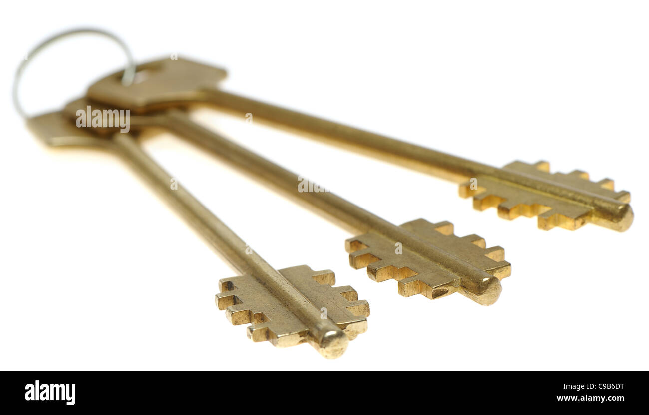 Three gold keys. Selective focus. It is isolated on a white background ...