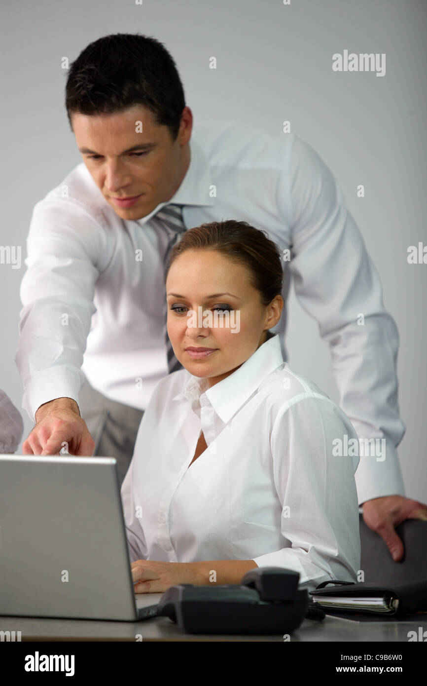Man explaining something to woman on laptop Stock Photo - Alamy