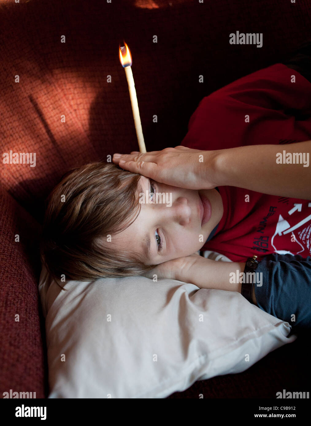 Boy having his ears cleared with ear candle, ear candling Stock Photo ...
