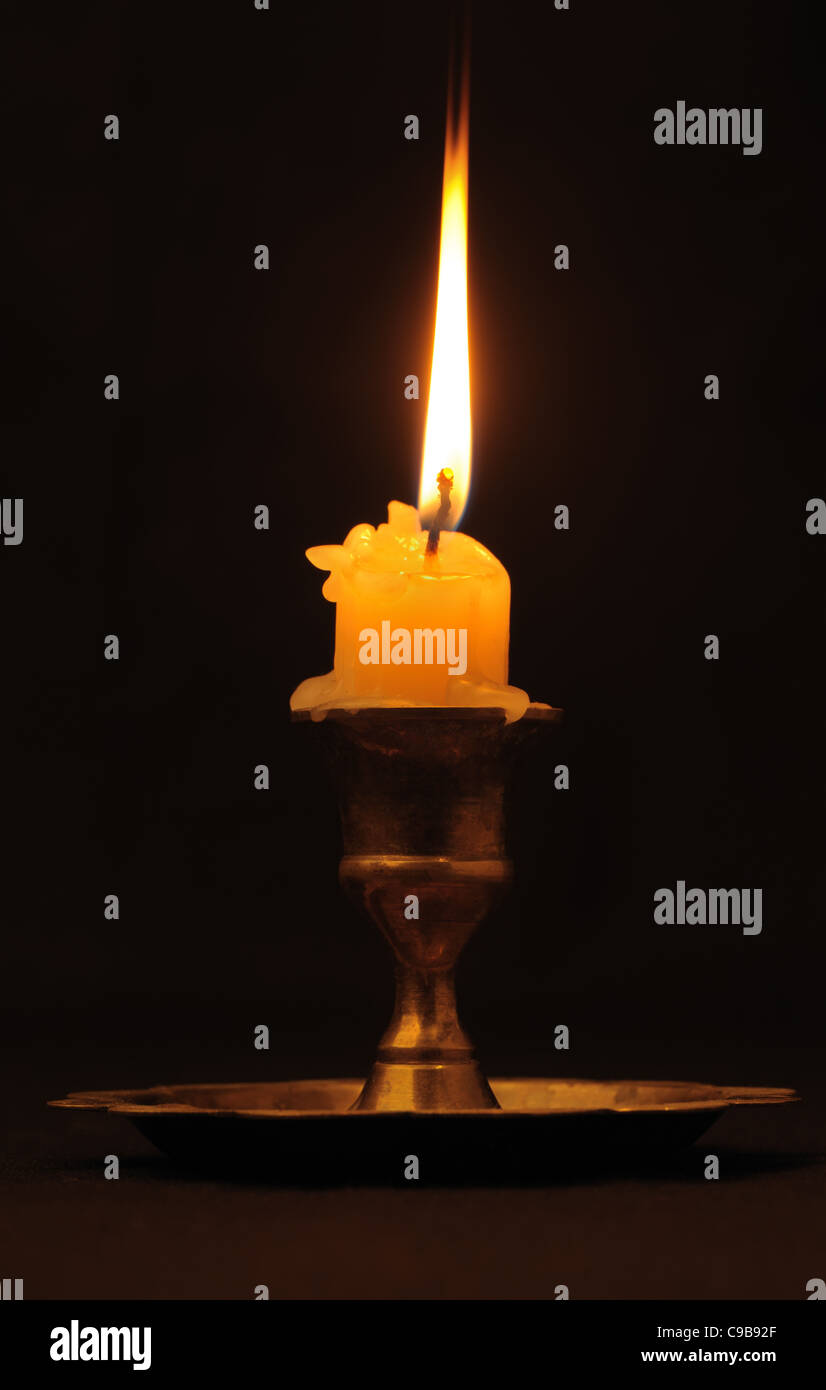 Burning candle. An ancient candlestick, a dark background Stock Photo ...