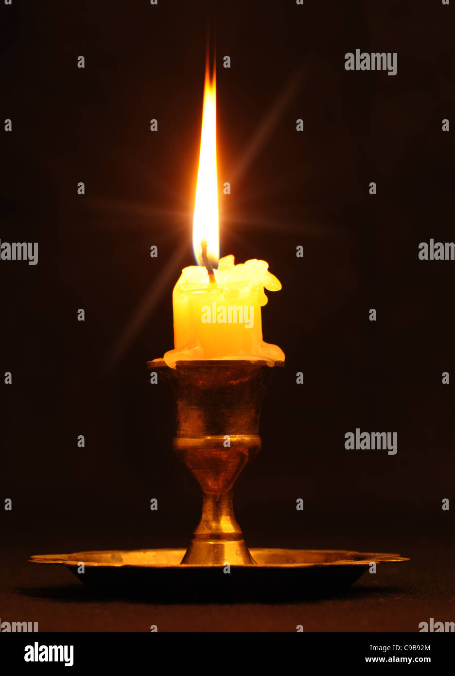 Burning candle. An ancient candlestick, a dark background Stock Photo ...