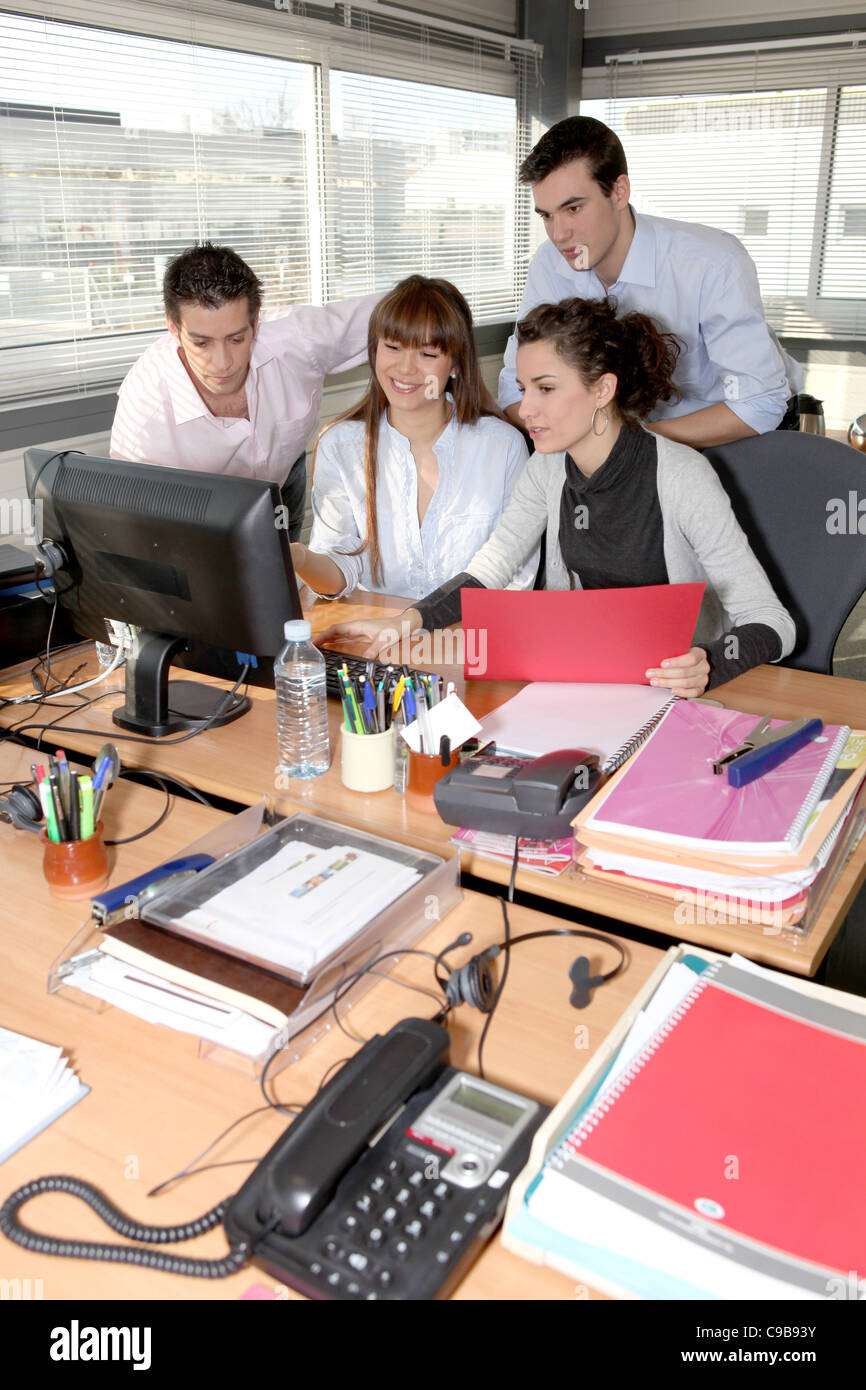 Co-workers looking at a computer Stock Photo - Alamy