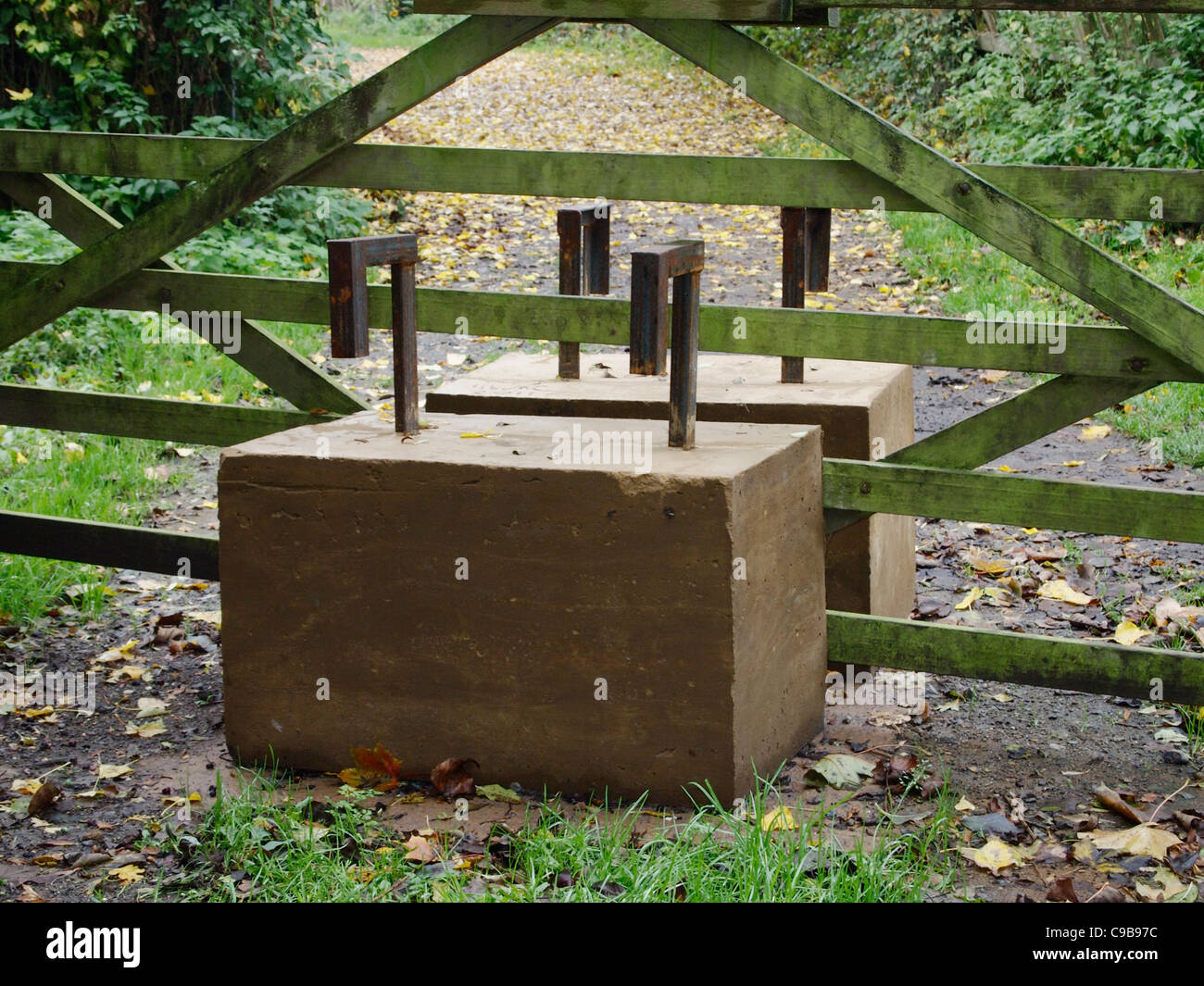 Heavy concrete blocks by a gate, barring vehicular access to a track or ...