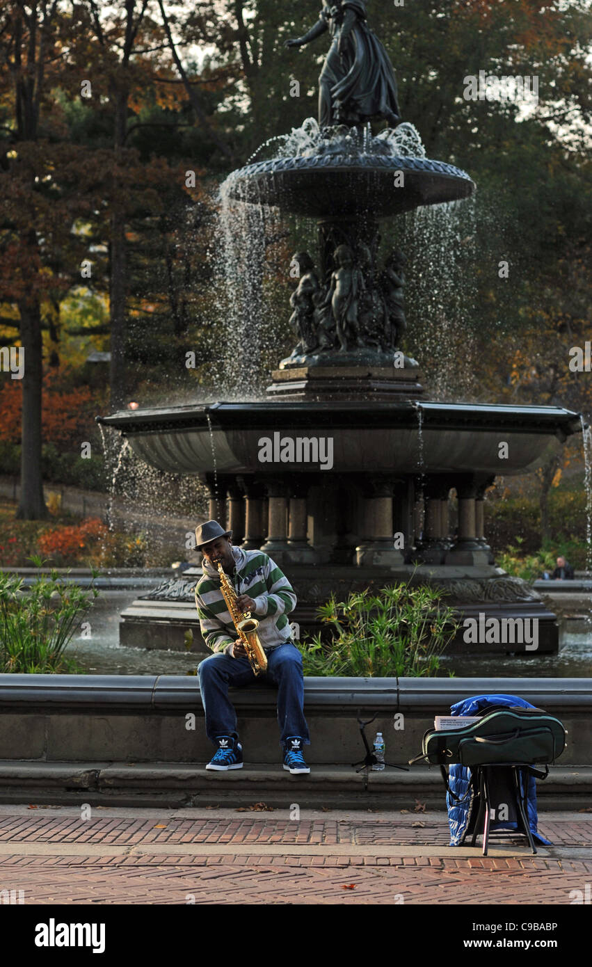 Busker performing with saxophone by water fountain in Central Park ...