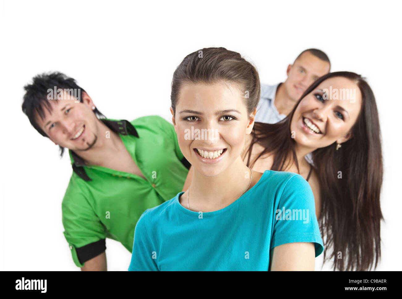 Four smiling young people standing behind each other Stock Photo - Alamy