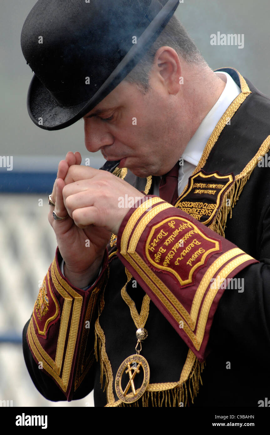 A member of the Apprentice Boys of Derry, stops to light his pipe ...