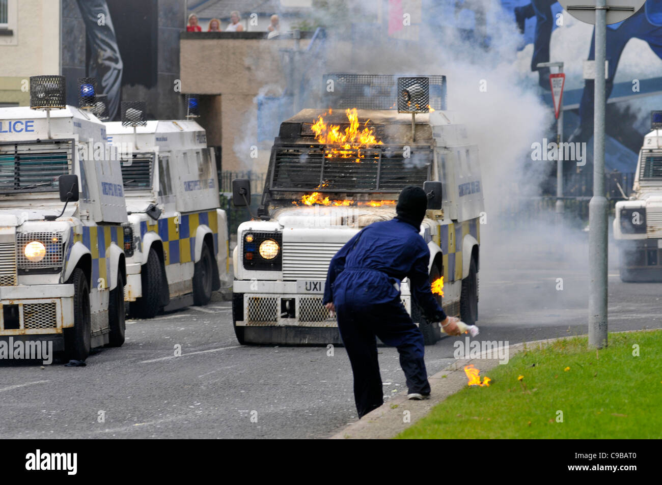 A masked nationalist youth prepares to throw a petrol bomb at a PSNI ...