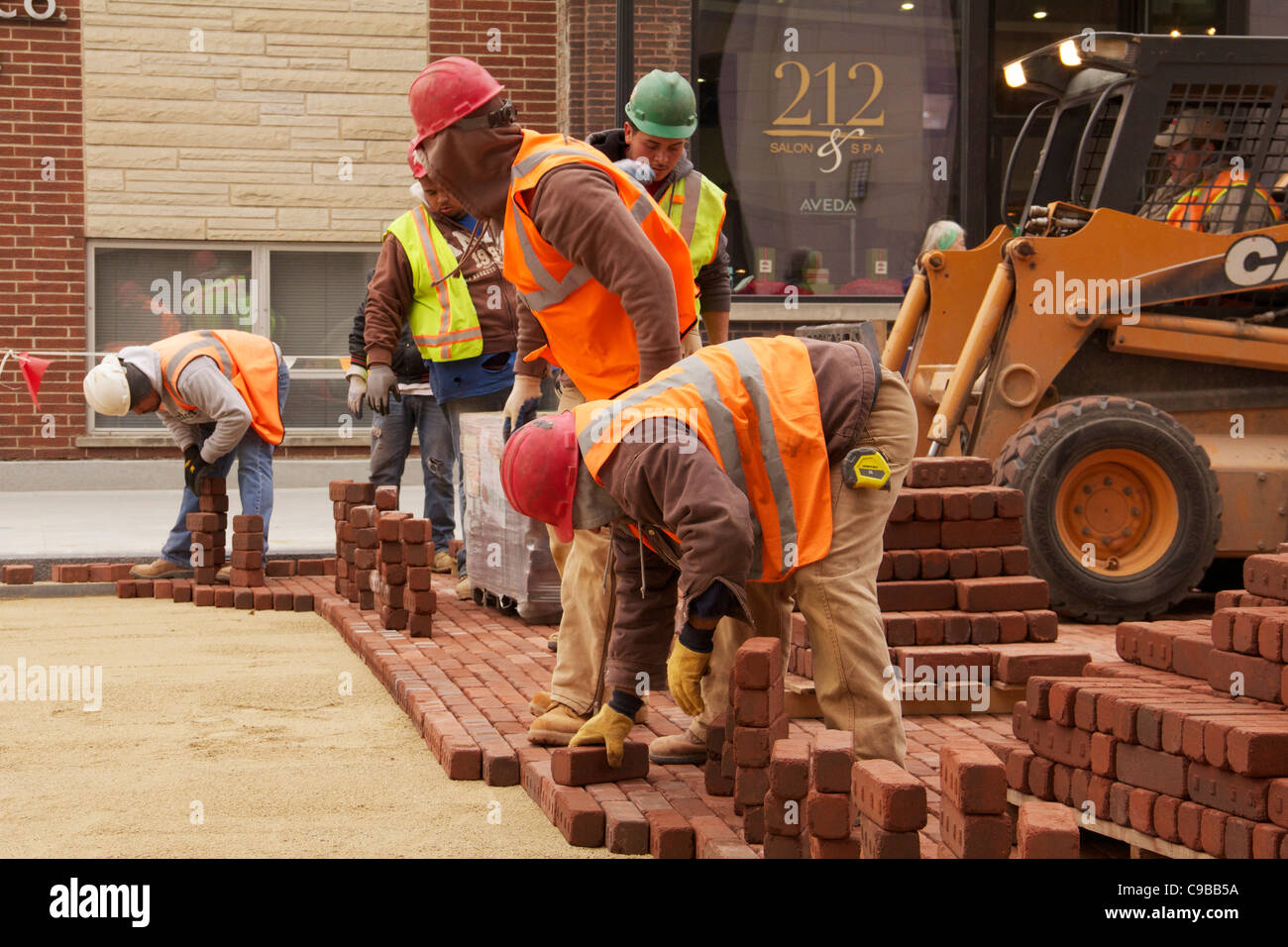 Construction workers lay paving bricks during Marion Street ...