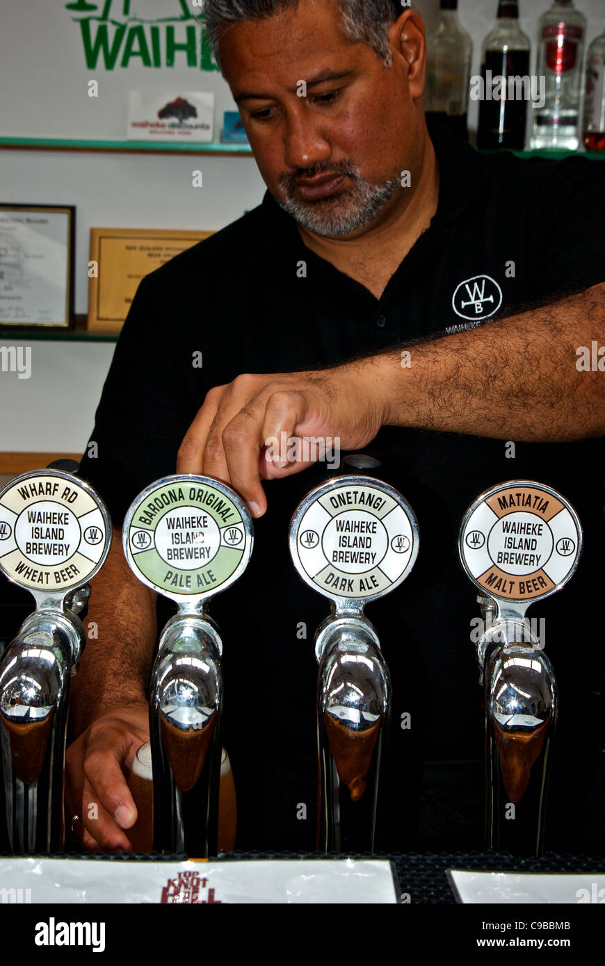 Publican pulling frosty pint of pale ale on tap from selection of beers ...