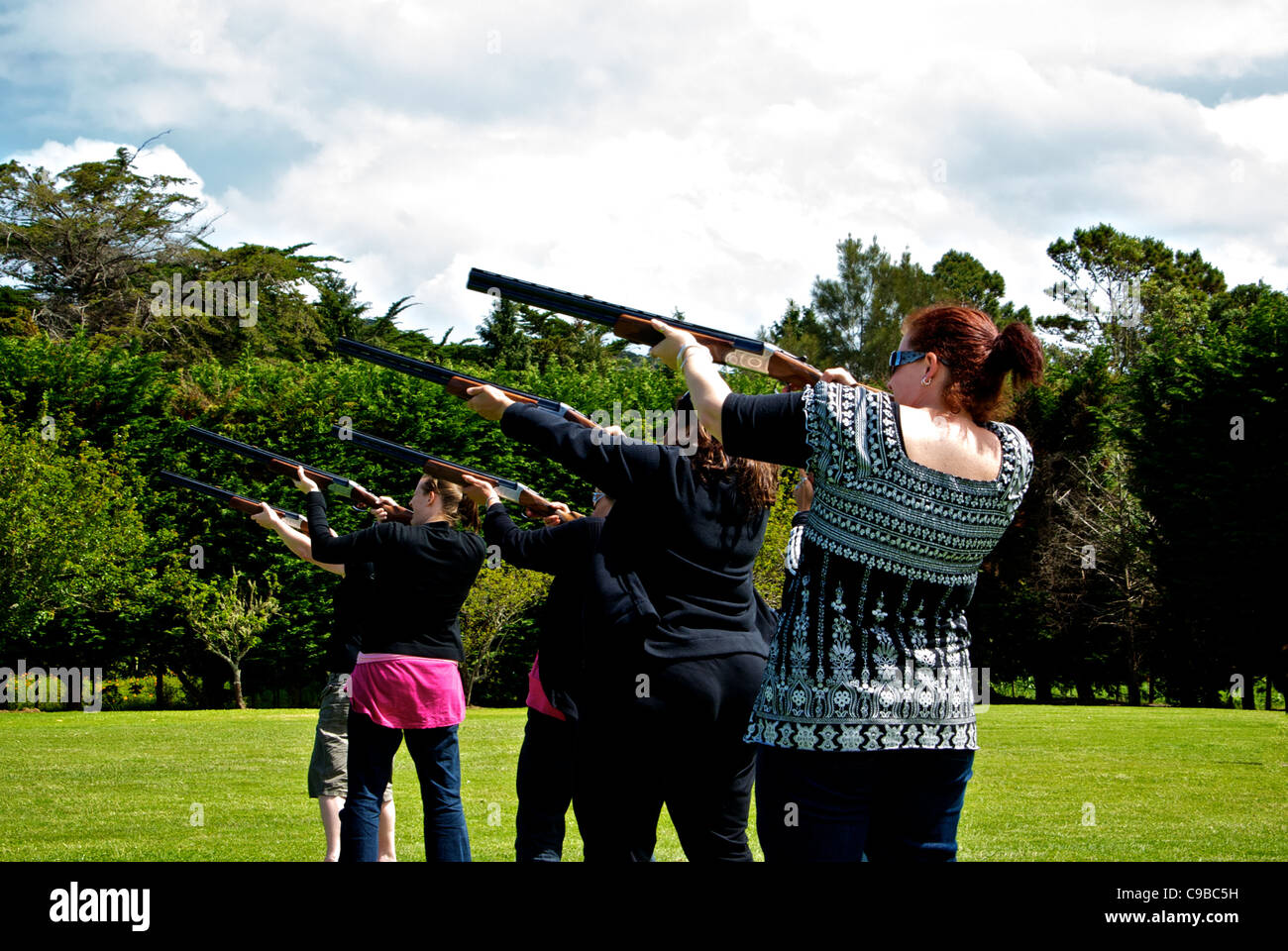 Team of women competing in a friendly round of laser skeet shooting at ...